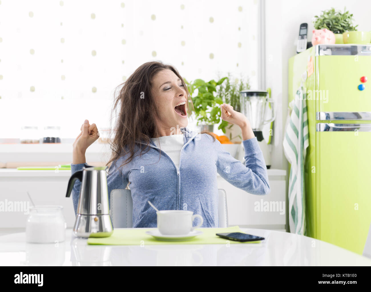 Tired lazy woman having breakfast at home in the kitchen, she is ...