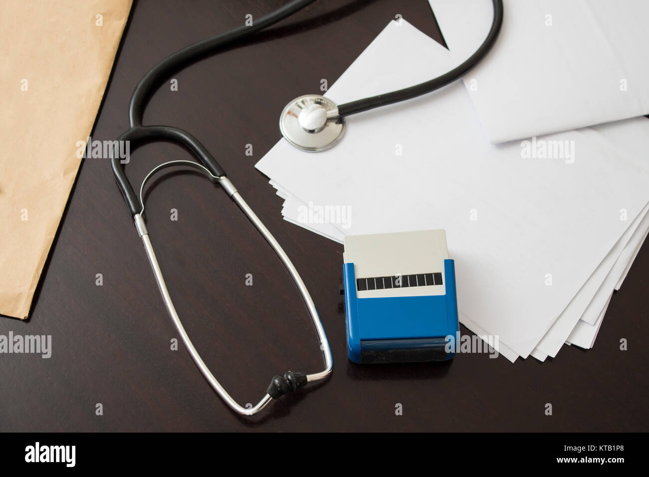 desk doctor. stethoscope,stamp and documents laying on a dark table ...