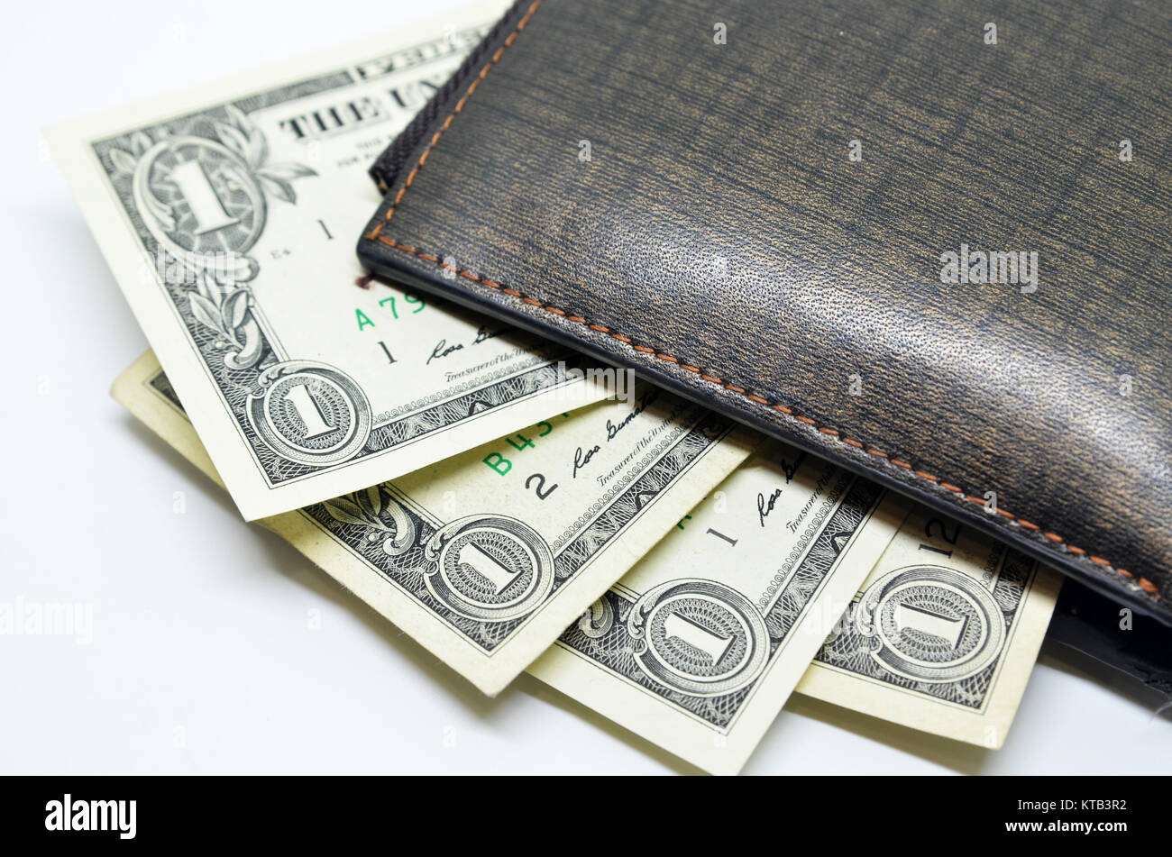Money sticking out of a leather wallet Stock Photo - Alamy