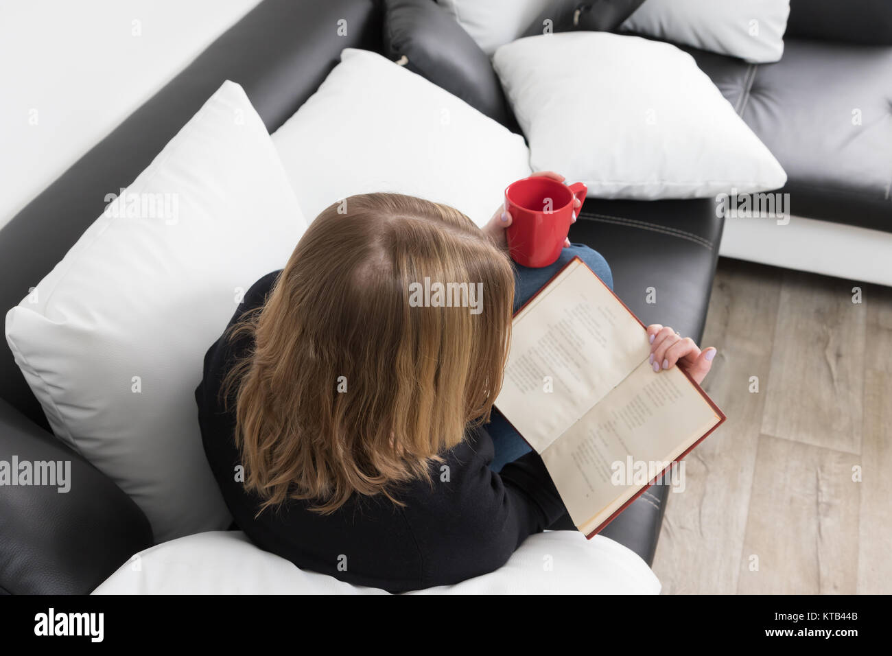 Aerial view of young woman reading a book Stock Photo - Alamy