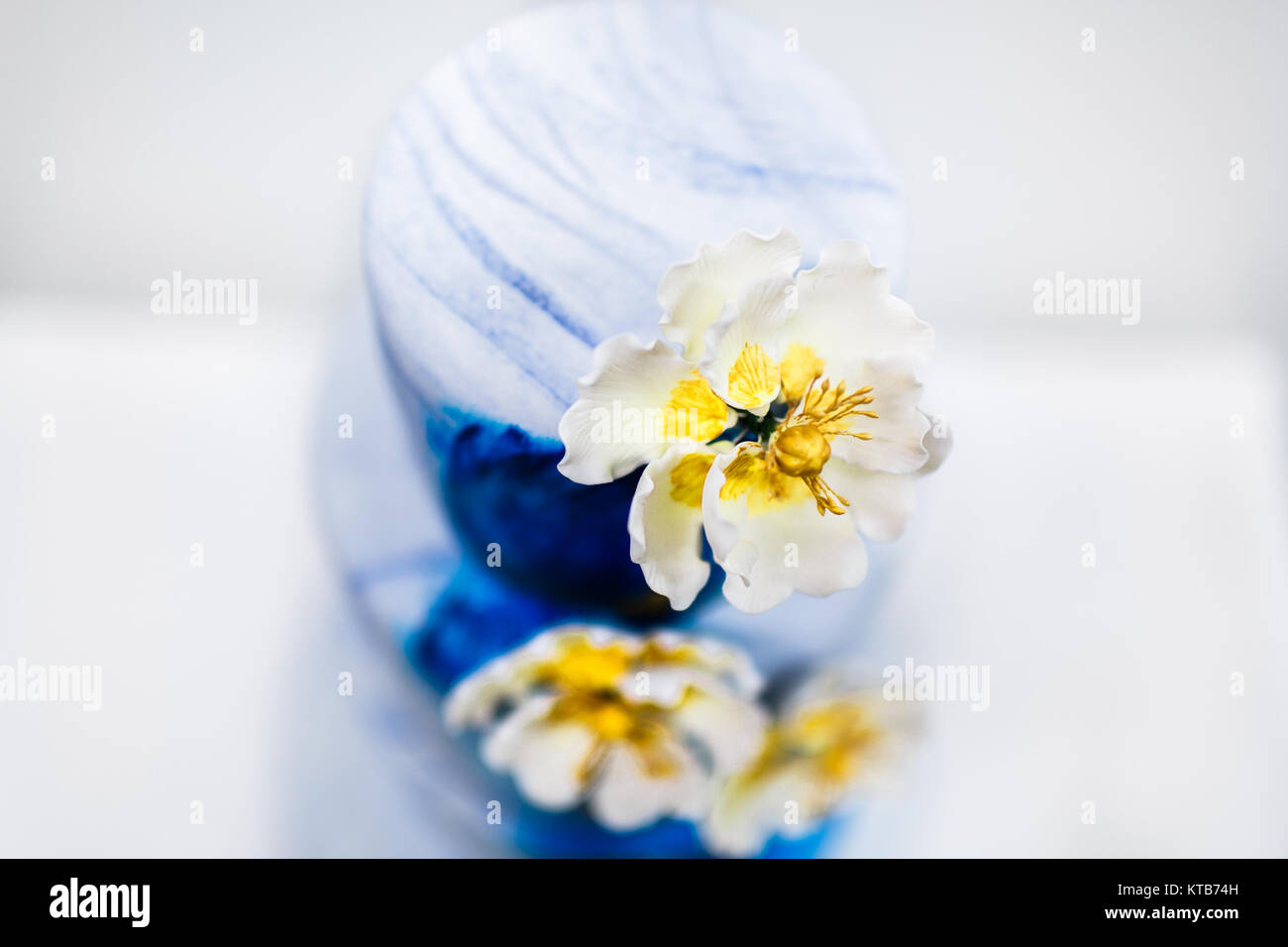 Multi level blue wedding cake with flowers Stock Photo - Alamy