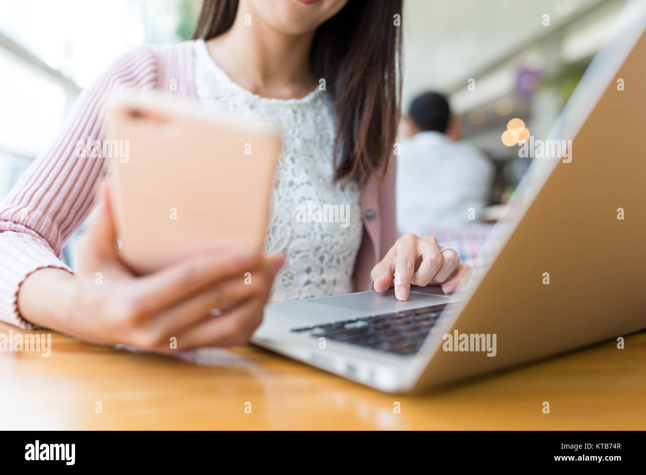 Woman using laptop computer and cellphone Stock Photo - Alamy