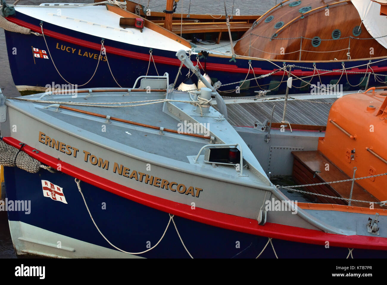 vintage lifeboats alongside on the harbour wall or docks at Wells next ...