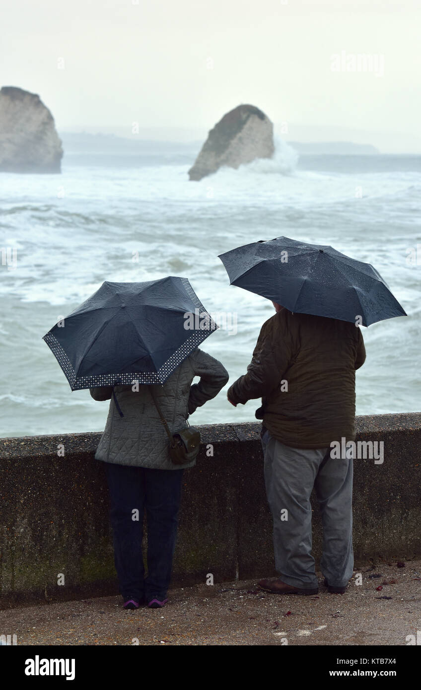 Two people or a man and a woman both with umbrellas standing at the ...