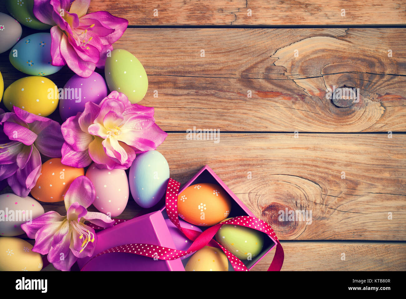Easter background with Easter eggs and flower on wooden table. Top view ...