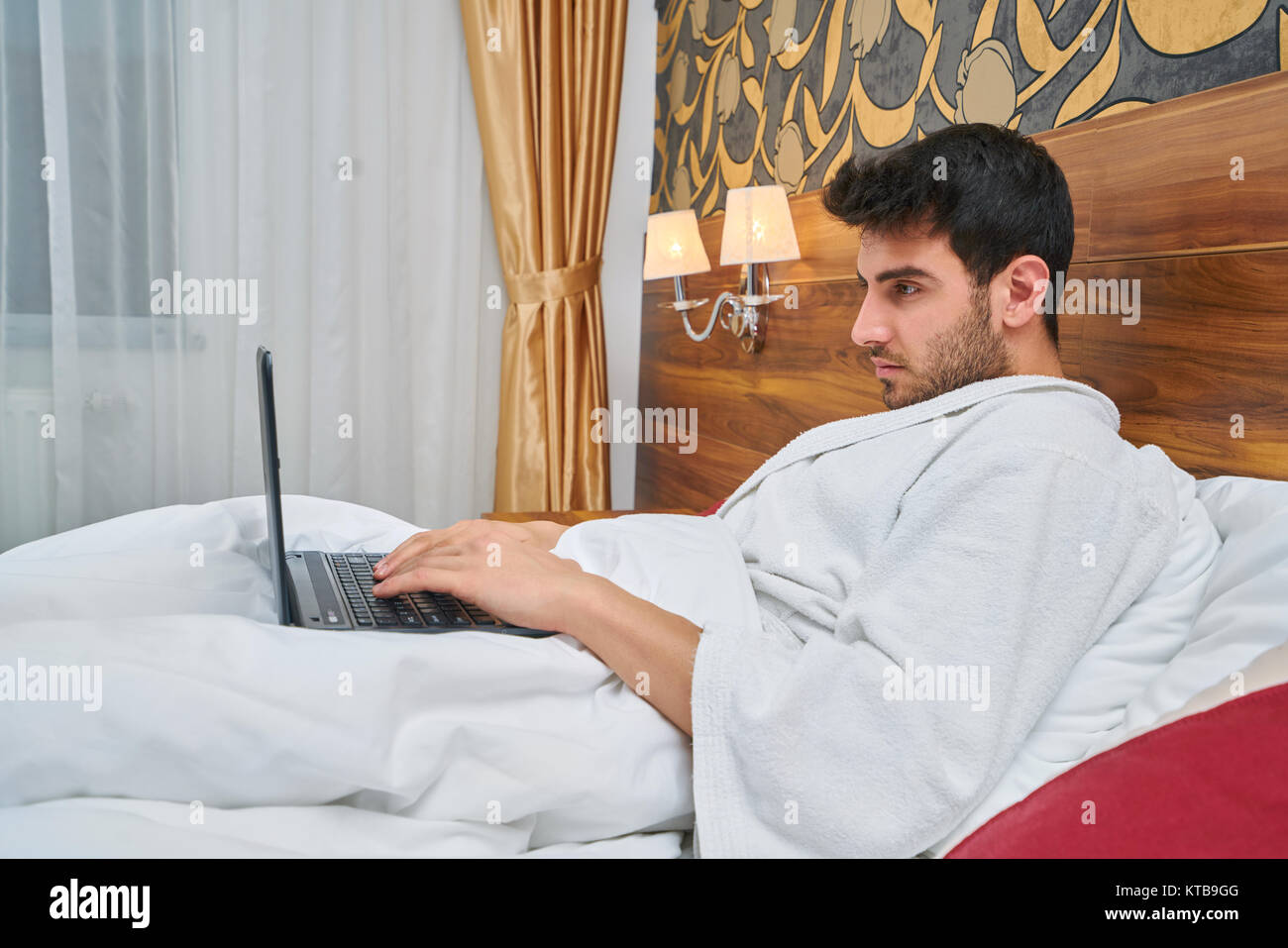 Laptop computer on white bed sheets in cozy room with copy space blank ...