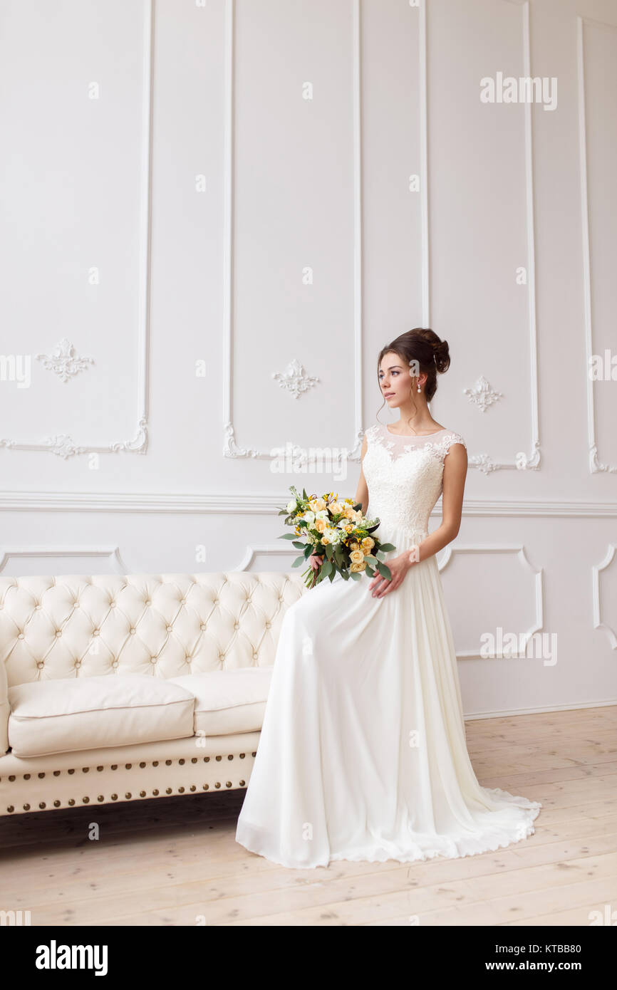 Beautiful bride sitting on the sofa Stock Photo - Alamy
