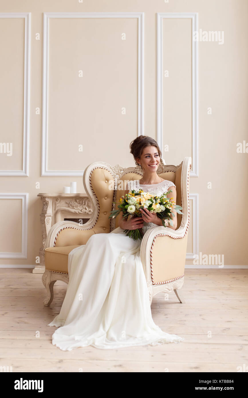 Beautiful bride sitting on the sofa Stock Photo - Alamy