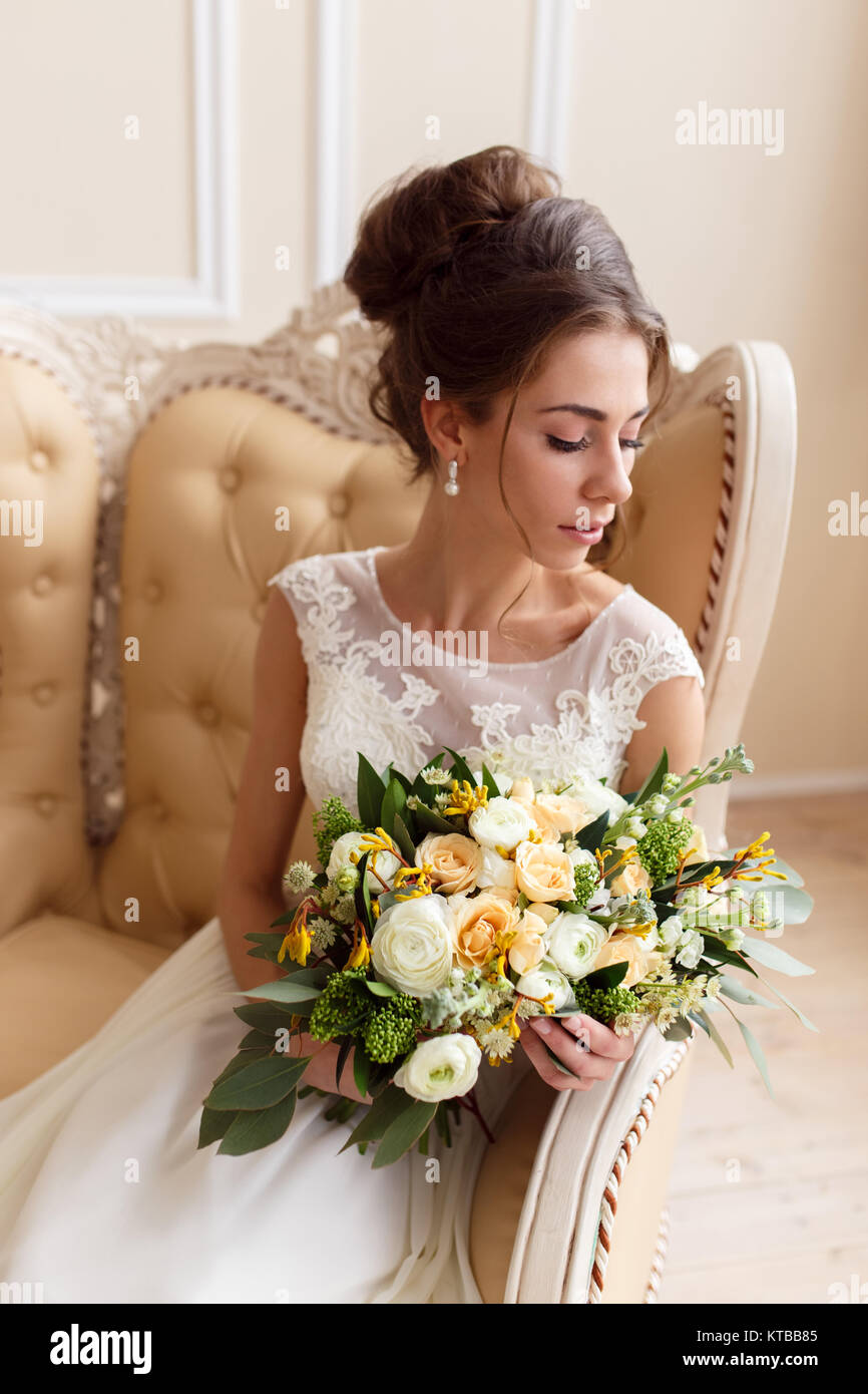 Beautiful bride sitting on the sofa Stock Photo - Alamy