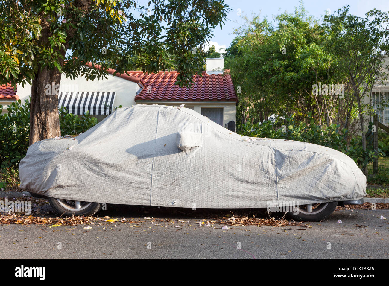Car under a protective cover parked on the roadside in the city Stock ...