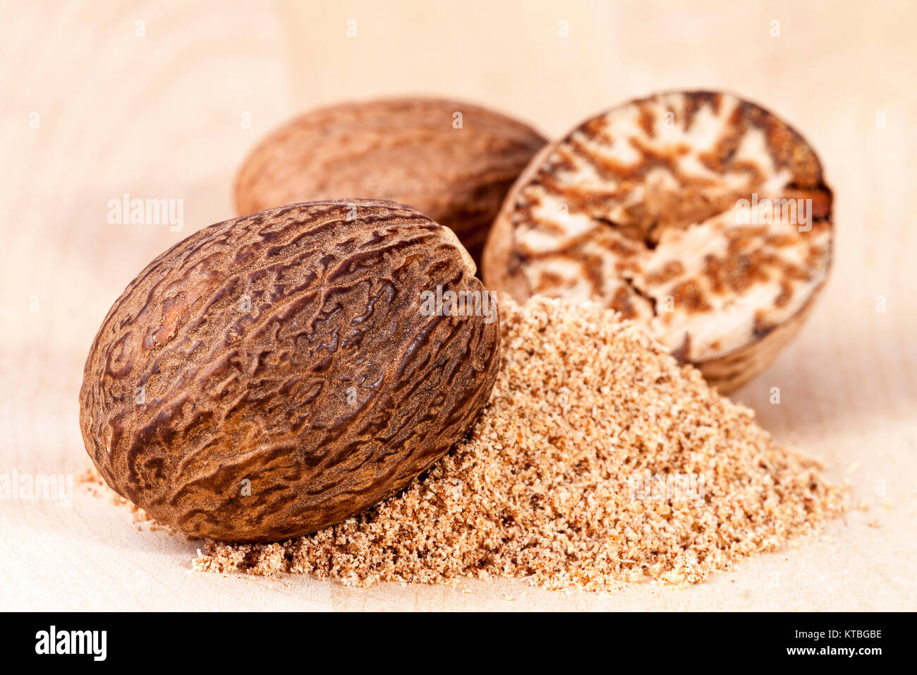 Nutmeg , whole and half on wooden plank, close up Stock Photo - Alamy