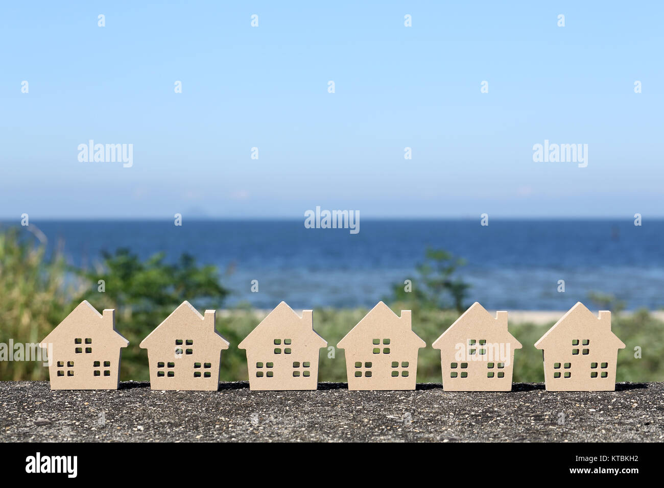 Miniature model of house with blue sea and sky background Stock Photo ...