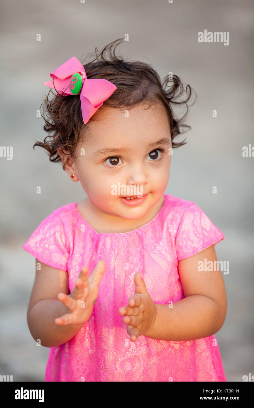 Baby girl dressed in pink clapping Stock Photo - Alamy