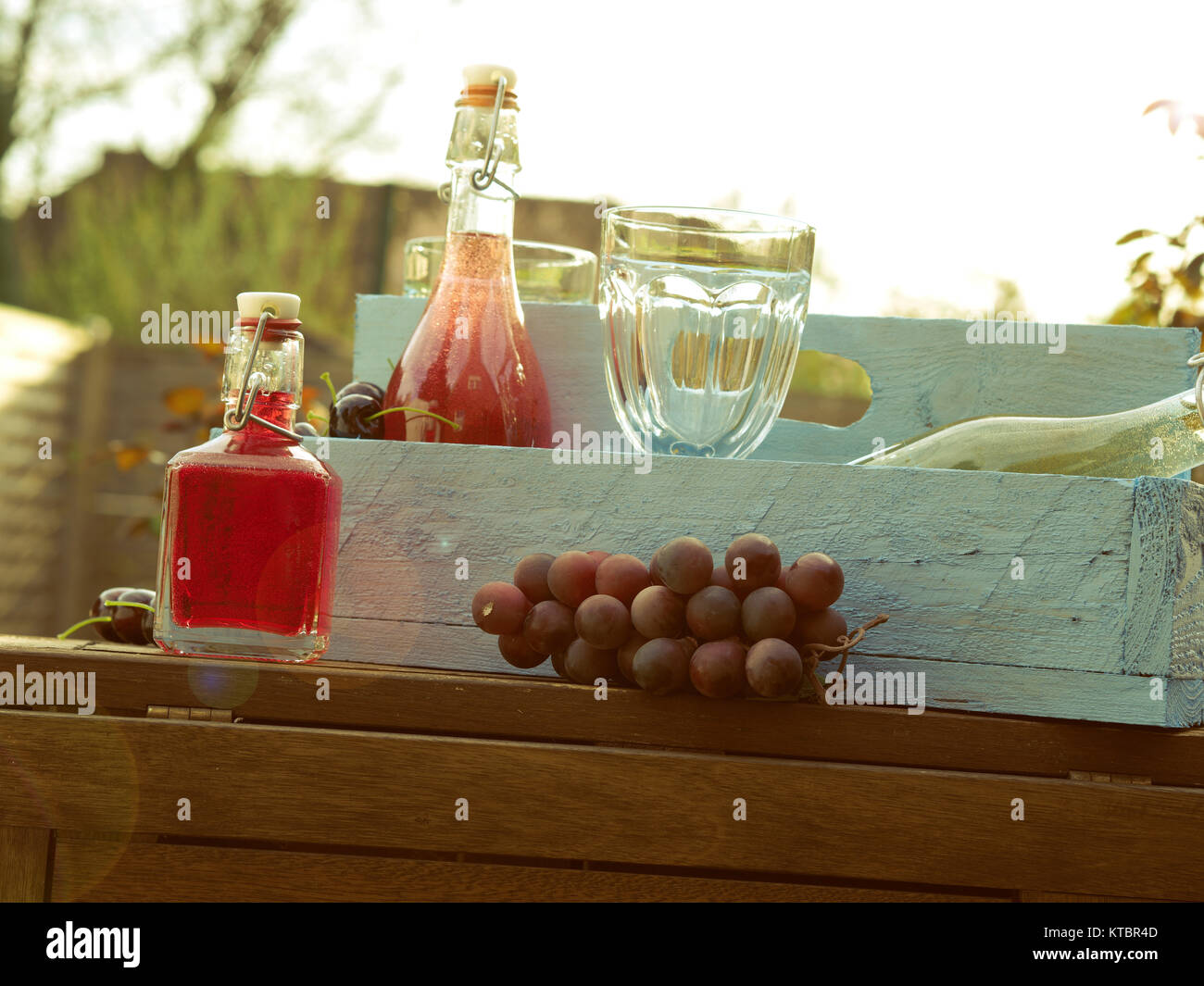 Summer drinks in a rustic wooden box with glasses in a garden at ...