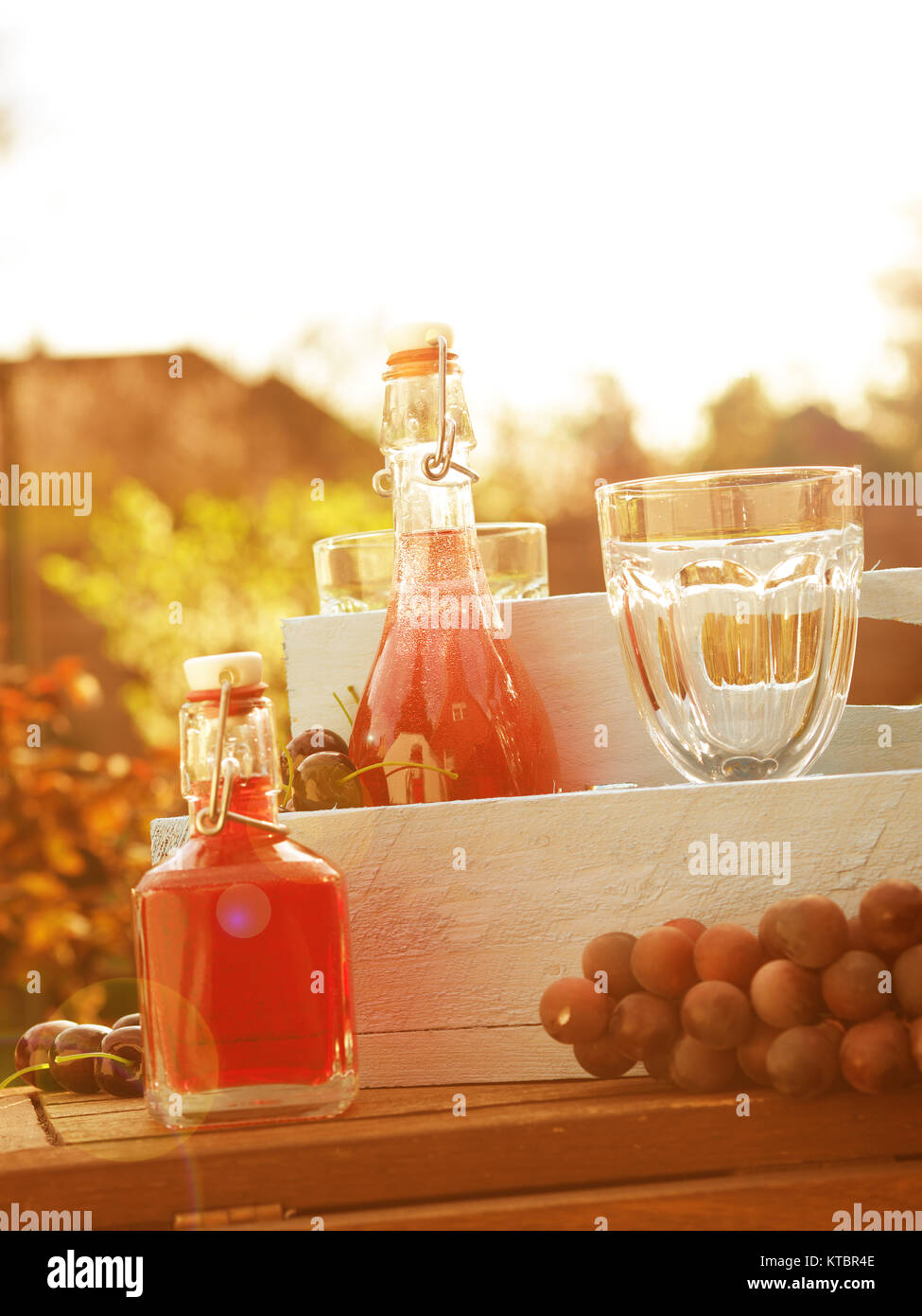 Summer drinks in a rustic wooden box with glasses in a garden at ...