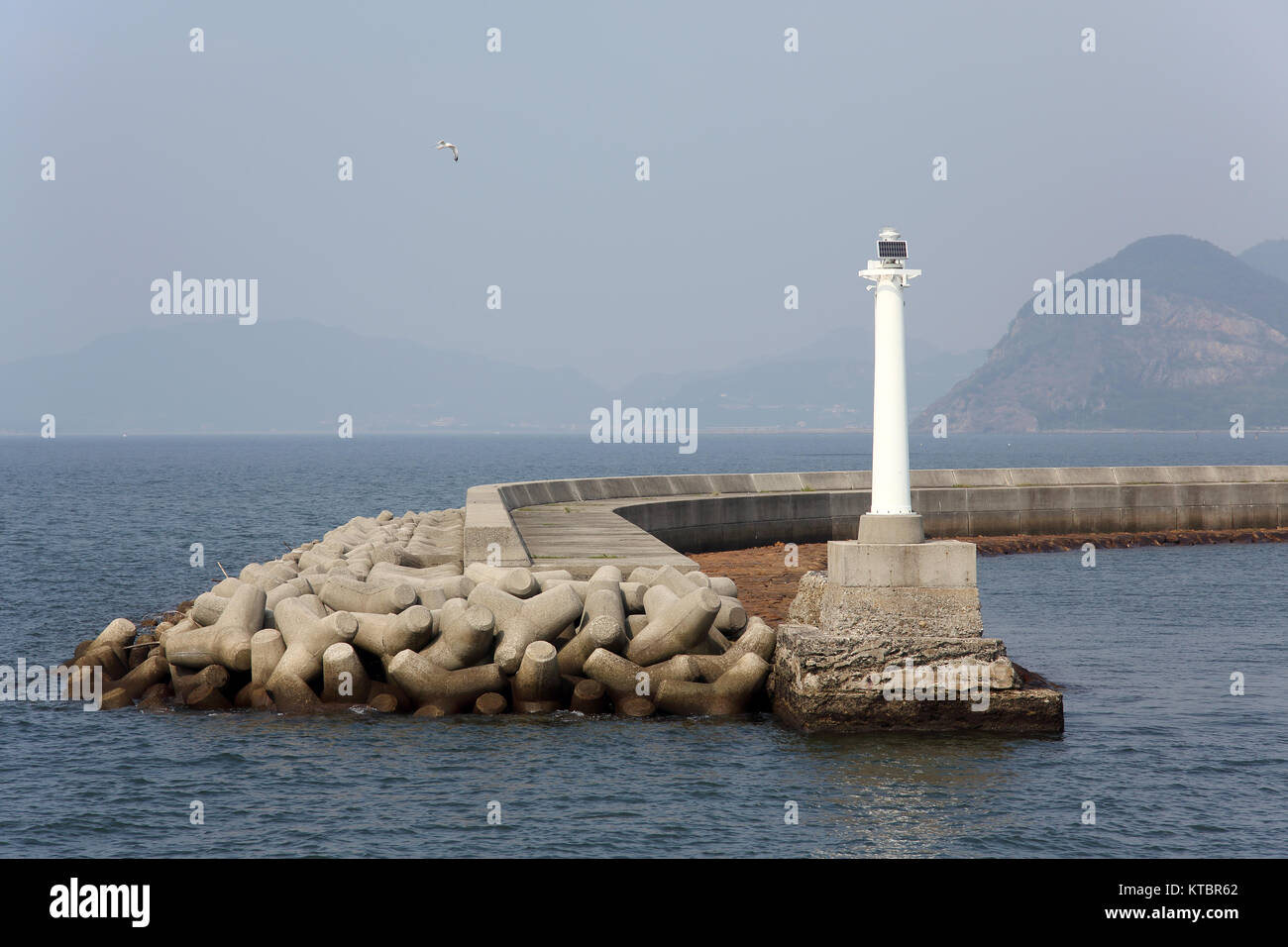 white lighthouse with jetty in the sea Stock Photo - Alamy