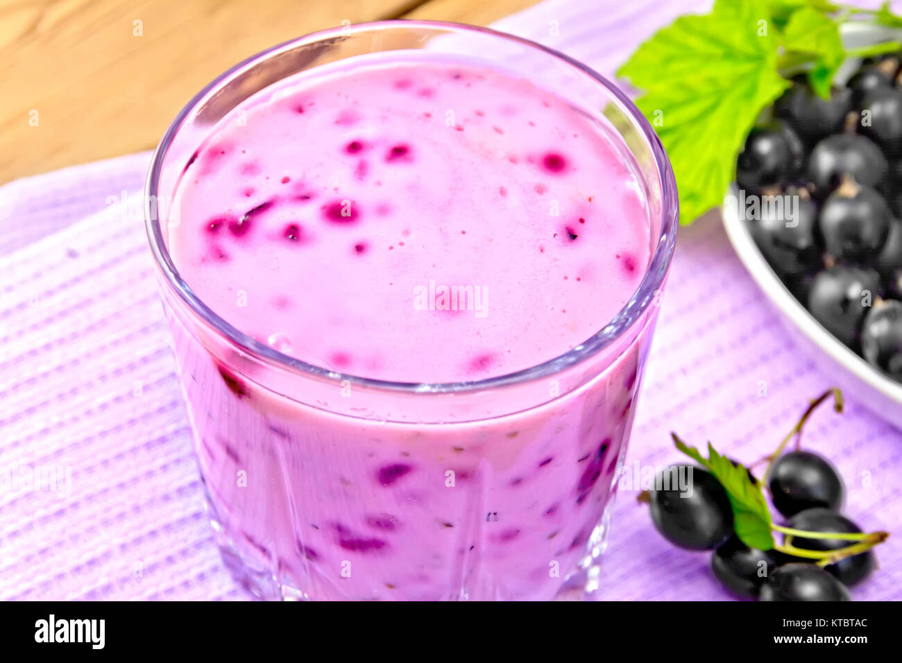 Milkshake with black currants in glass on wooden board Stock Photo - Alamy