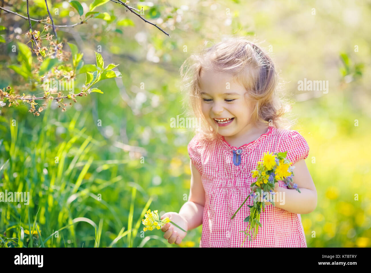 Happy little girl in spring sunny park Stock Photo - Alamy