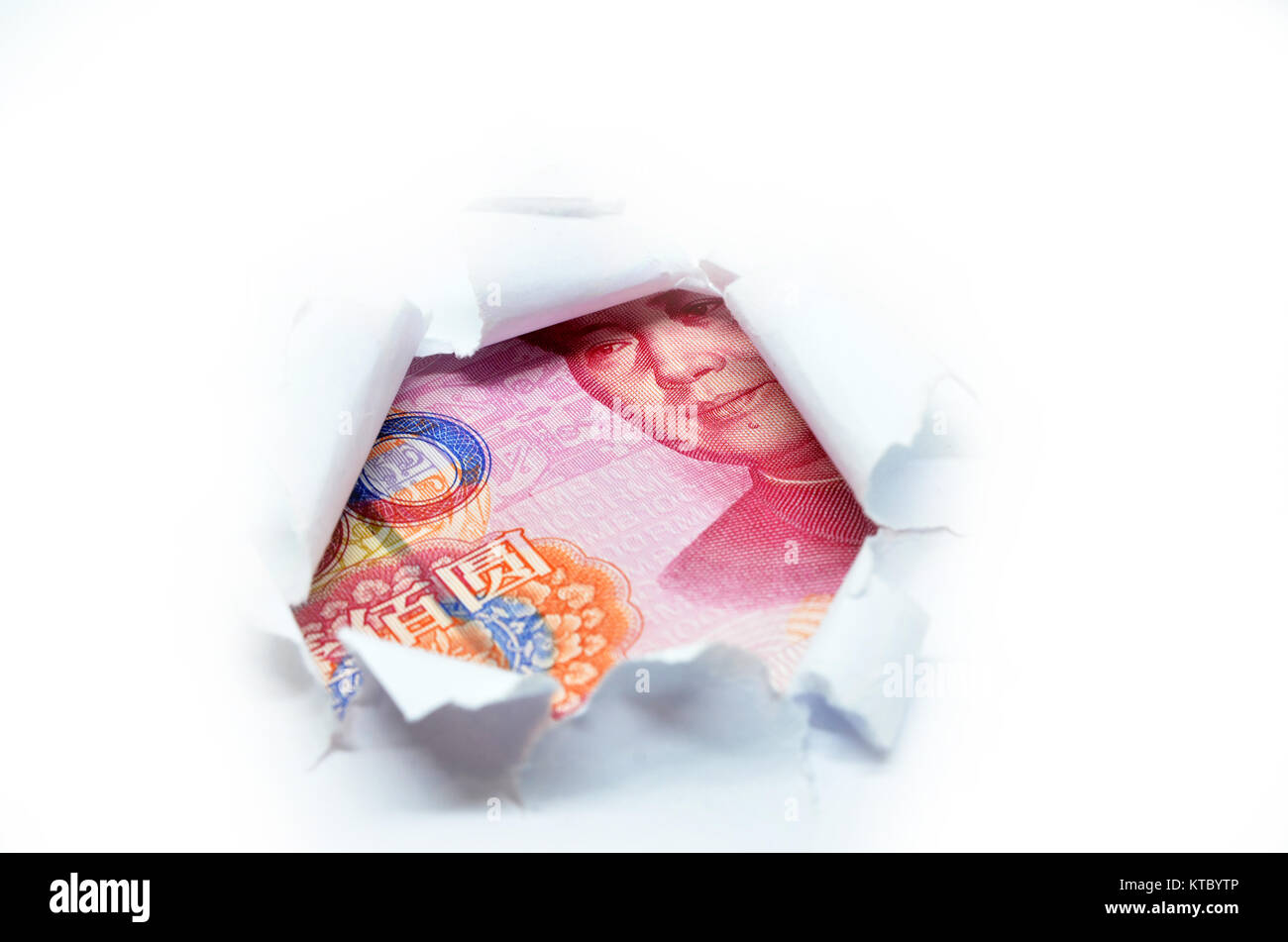 China currency through torn white paper Stock Photo - Alamy