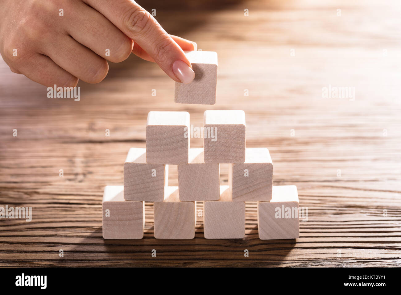 Woman Placing Block On Desk Stock Photo - Alamy