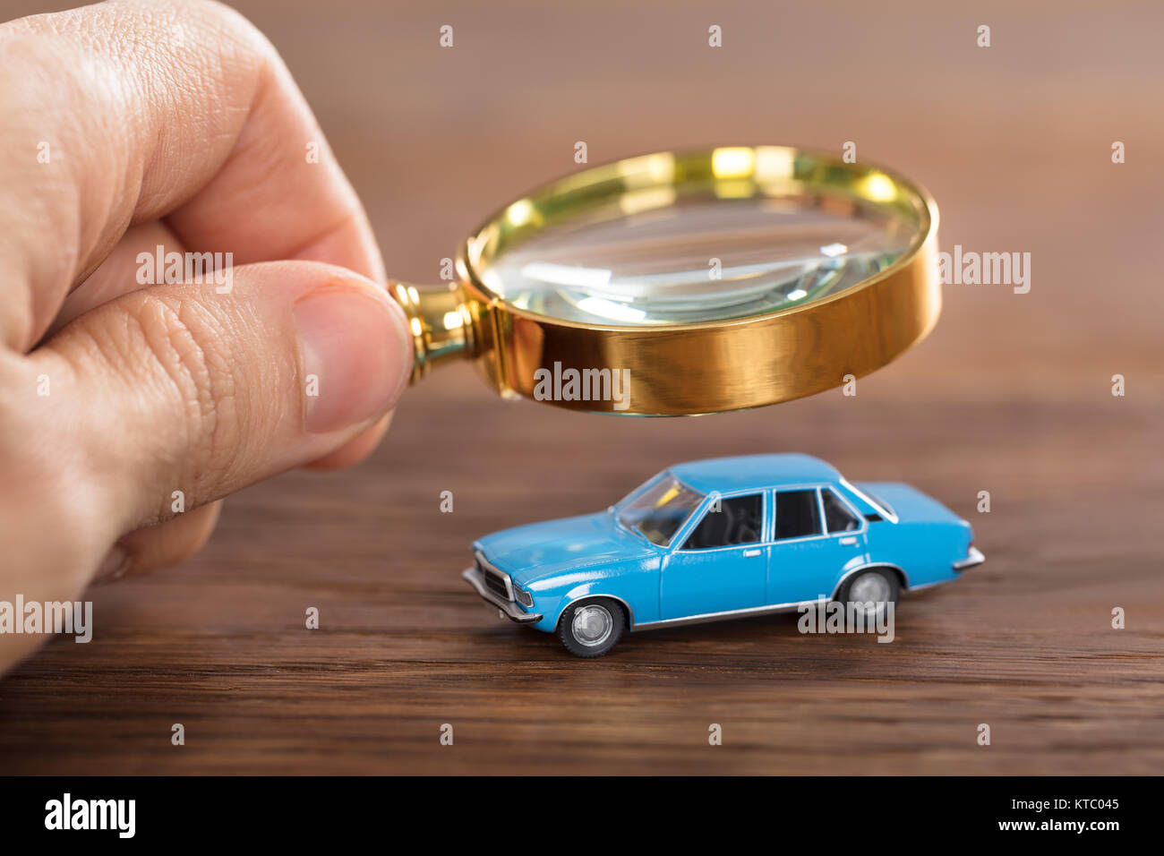 Person Using Magnifying Glass On Car Model Stock Photo - Alamy
