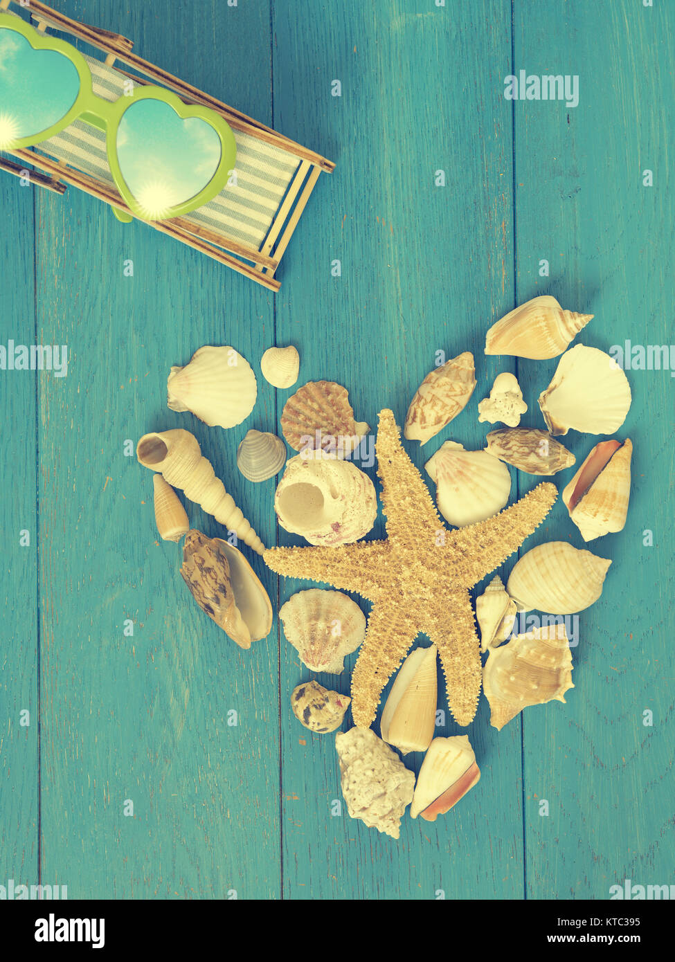 Heart shape of shells and a starfish on a blue vintage wooden ...