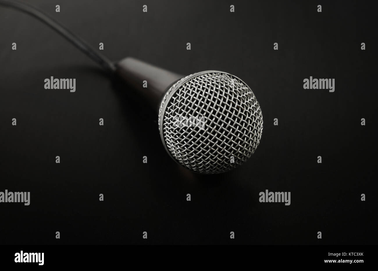 Microphone with cable high angle close up over black Stock Photo - Alamy