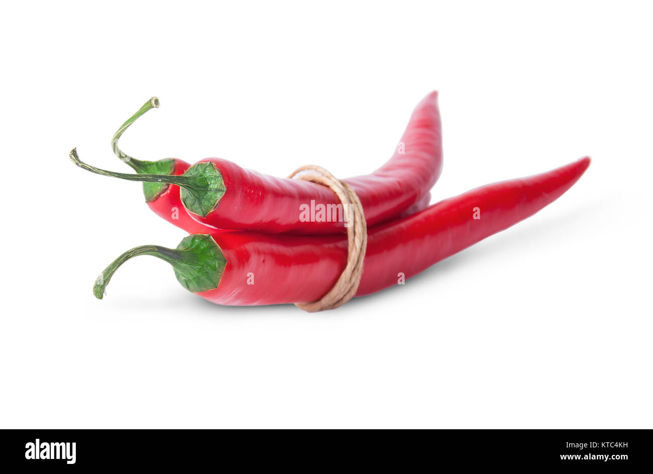 Three red chili peppers rotated tied with a rope Stock Photo - Alamy