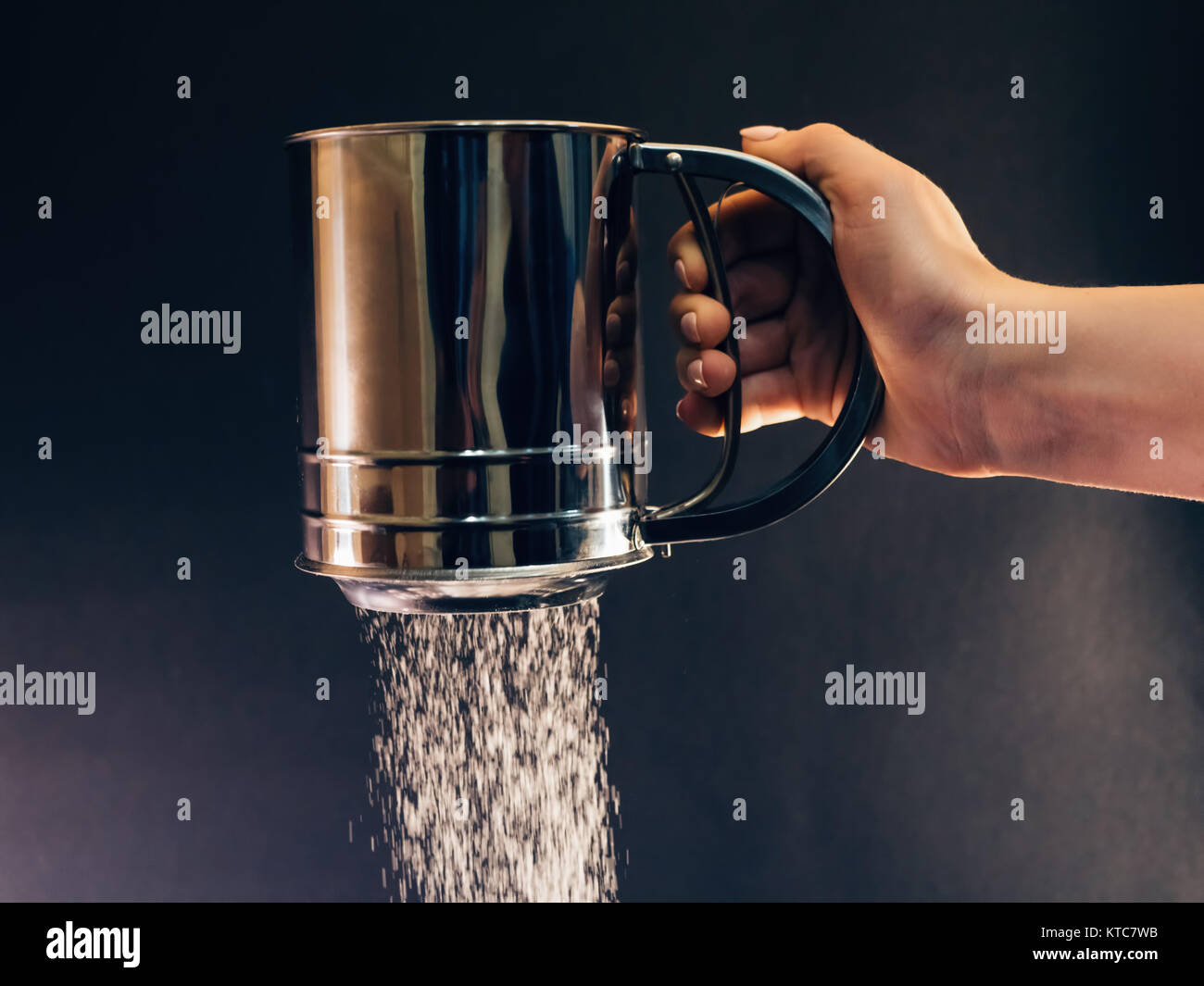 Female Hand sifting flour or sugar powder through sieve for baking ...
