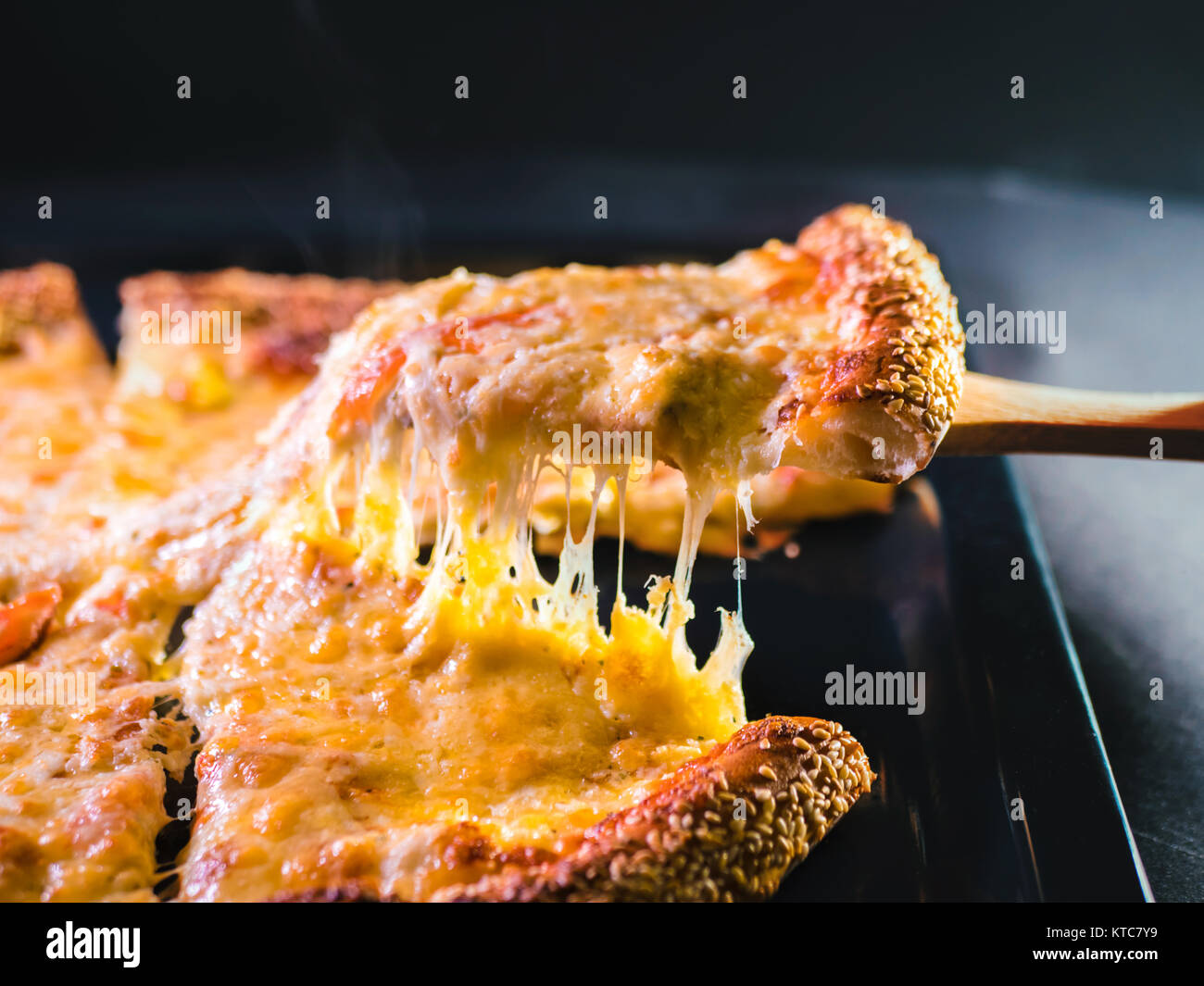 Cut off a slice of pizza. Melted cheese stretches from the piece Stock ...