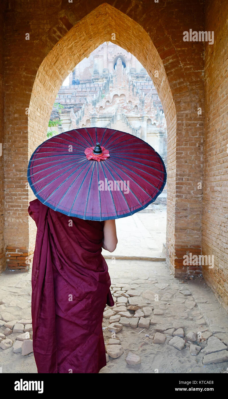 A Buddhist monk with red umbrella coming to the ancient temple Stock ...