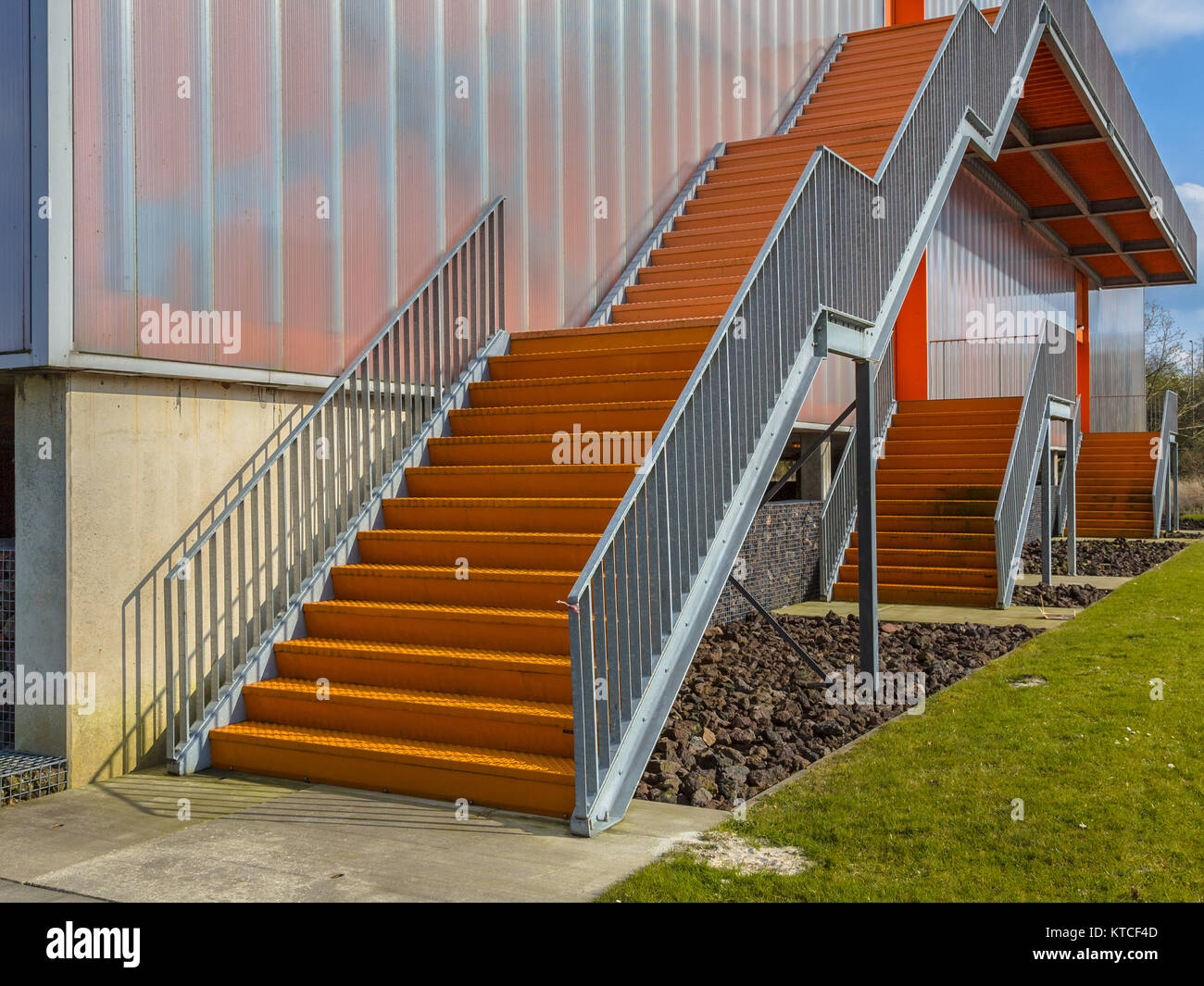 Orange emergency exit escape ladders on the exterior of a modern ...