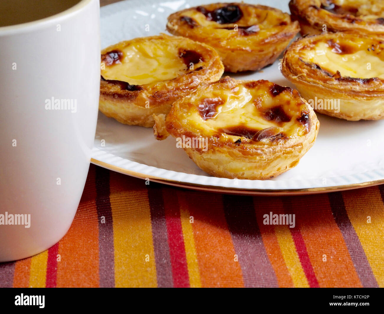 Custard tarts in a plate with a cup Stock Photo - Alamy