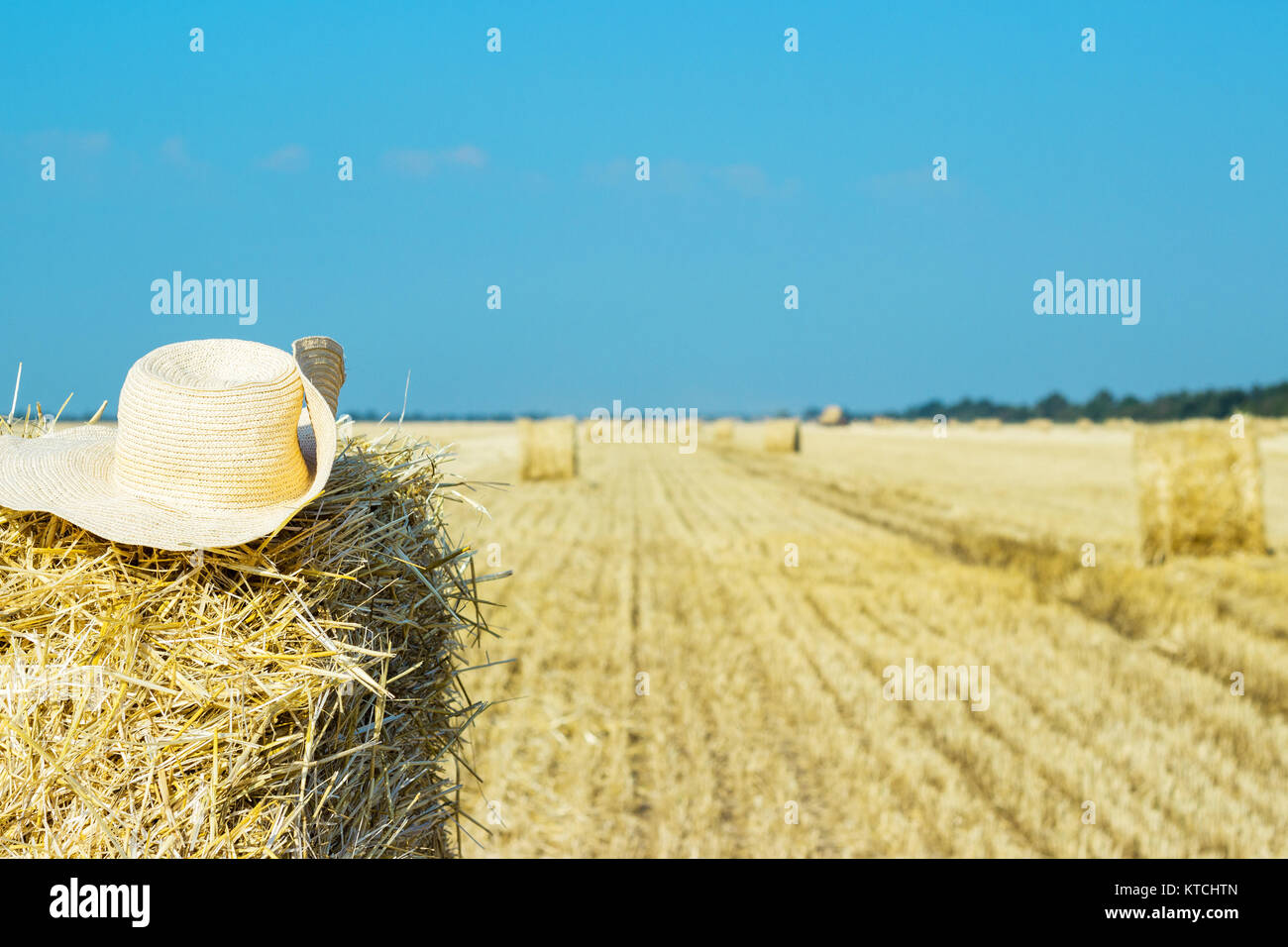 A lonely farmer's hat on a haystack in the field after a hard work ...