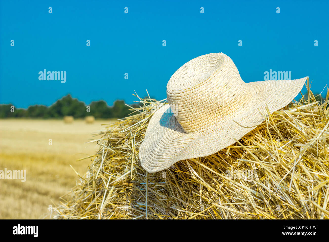 A lonely farmer's hat on a haystack in the field after a hard work ...
