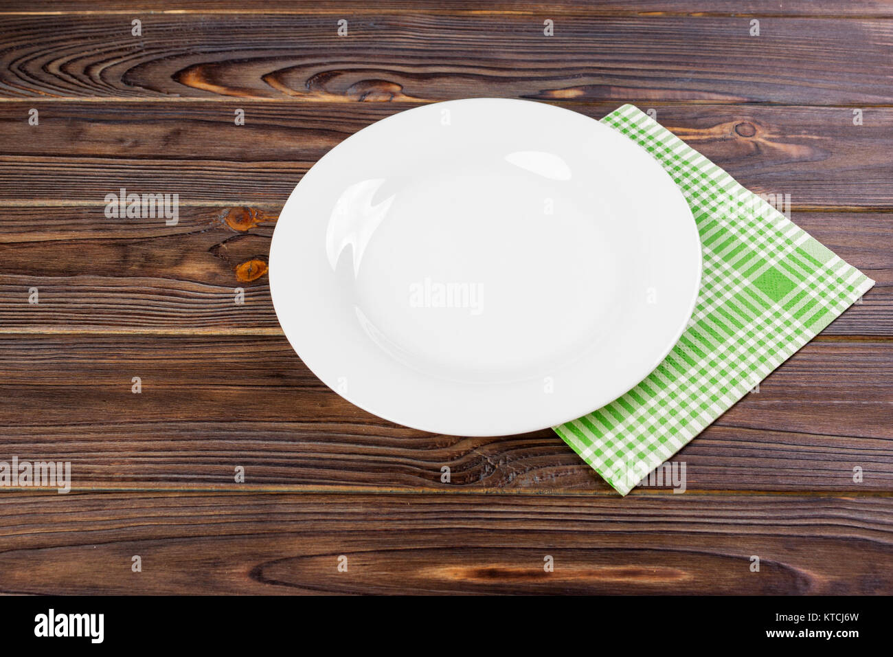Empty plate over wooden table background. View from above with copy ...