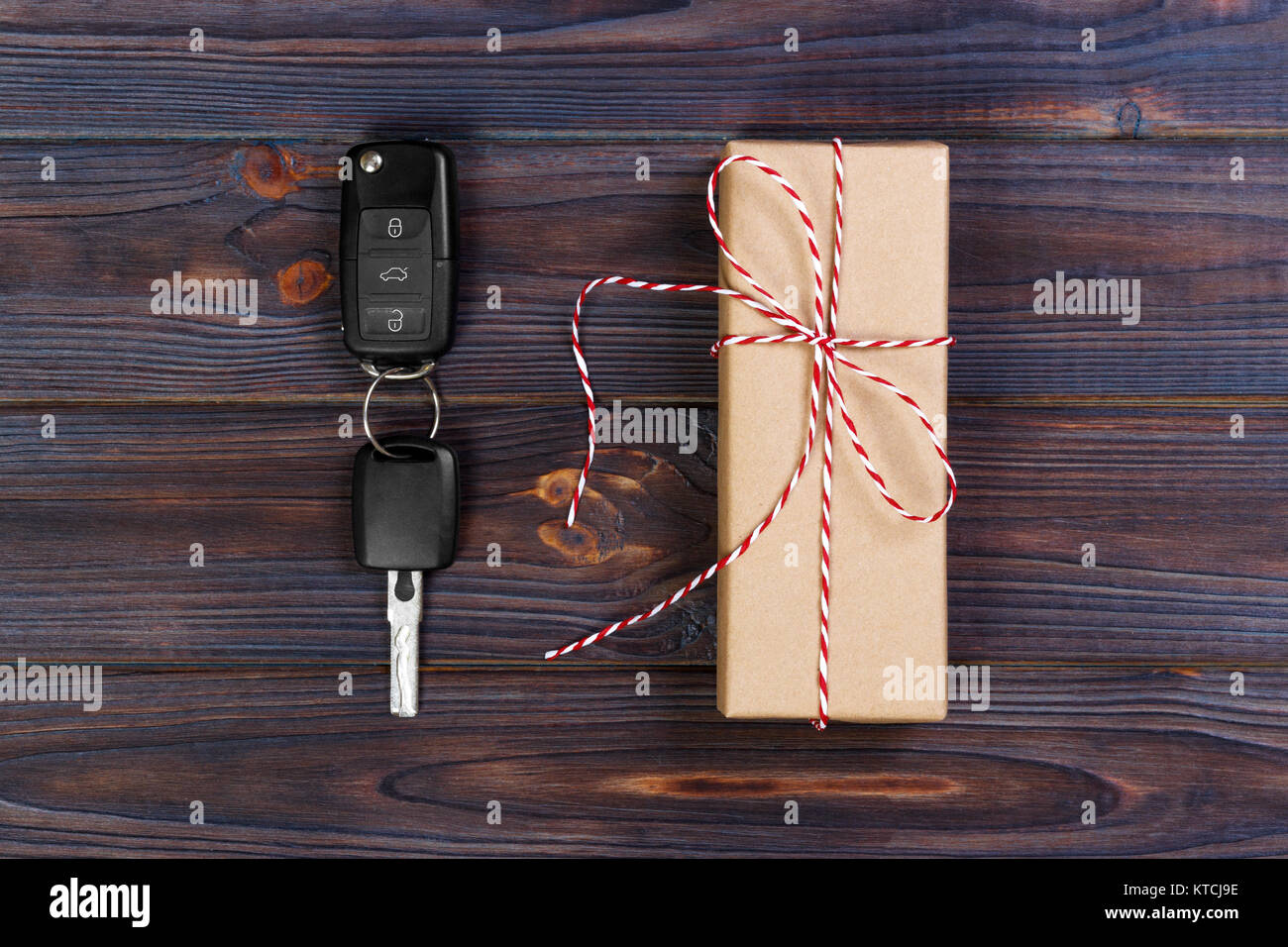 Car key near paper box with red ribbon bow on black natural background ...