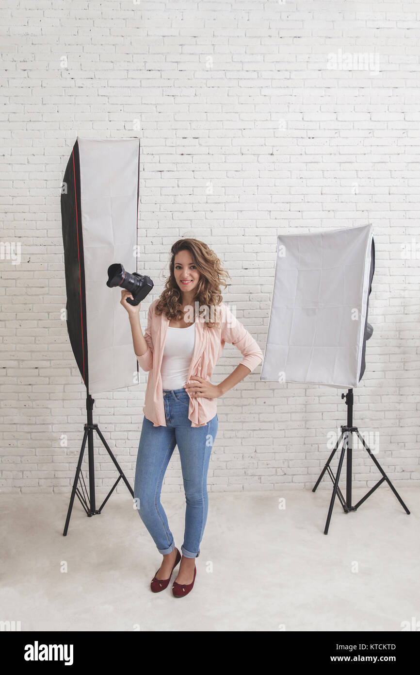 young woman with a camera in the studio with lighting on the bac Stock ...