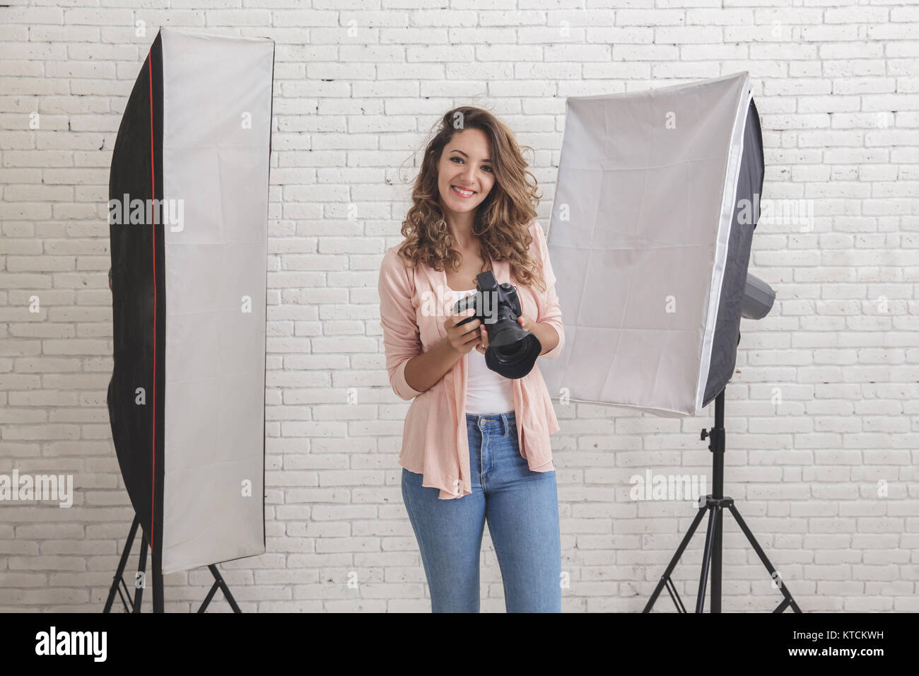 young female photographer in studio with lighting at the beackgr Stock ...