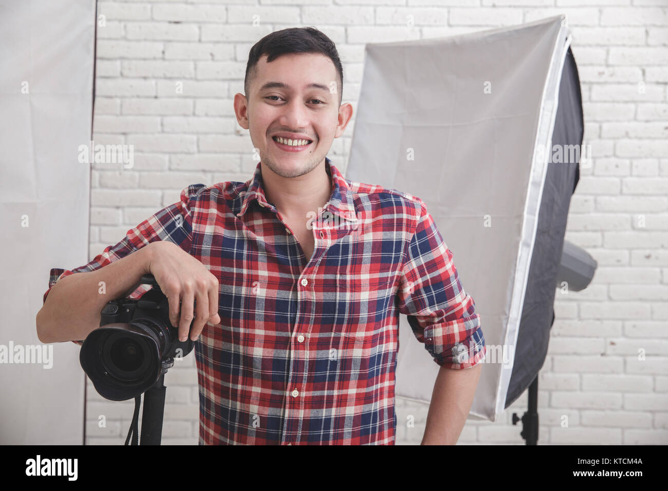 Young photographer with camera in professionally equipped studio Stock ...