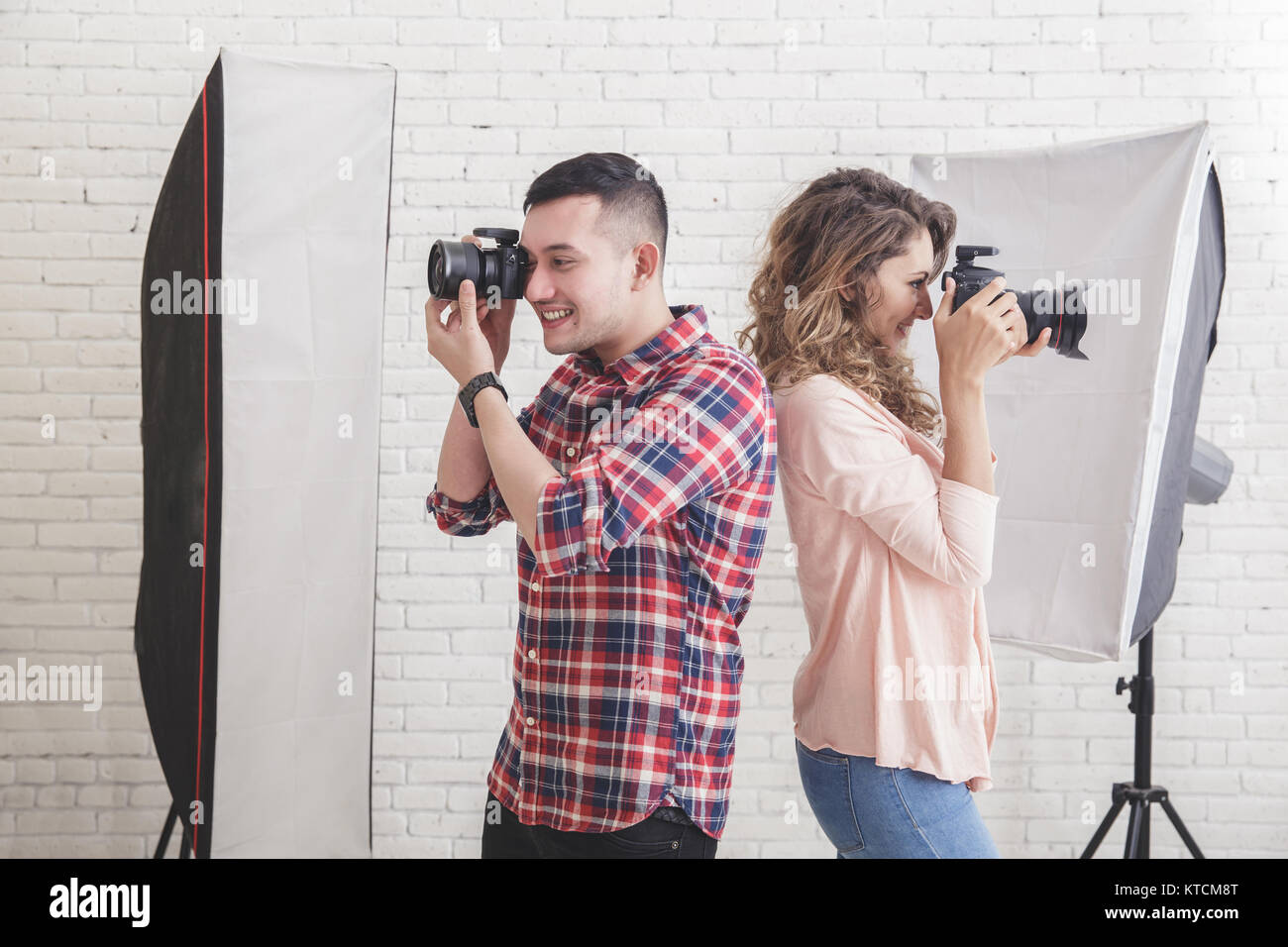 two young photographers back to back taking a photos Stock Photo - Alamy