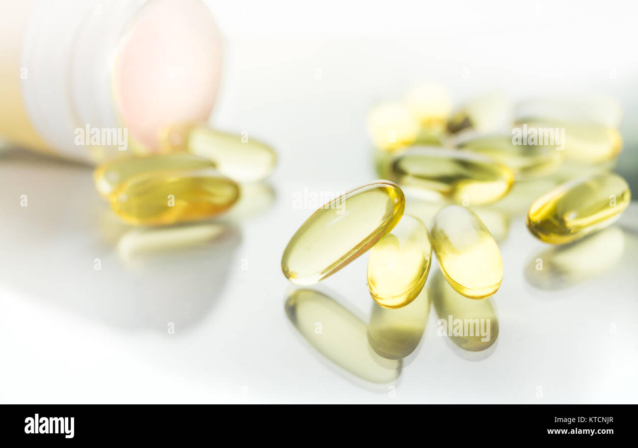 Vitamin soft gel capsules on white shiny backdrop close up Stock Photo ...