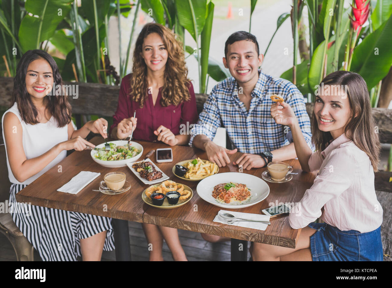 group of four best friend having their lunch together at a cafe Stock ...