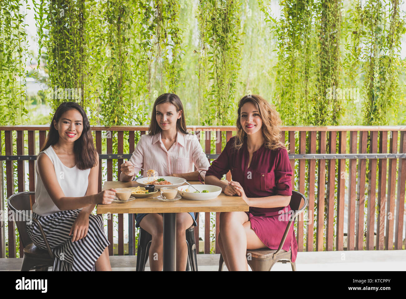group of three best friend having their lunch together at a cafe Stock ...