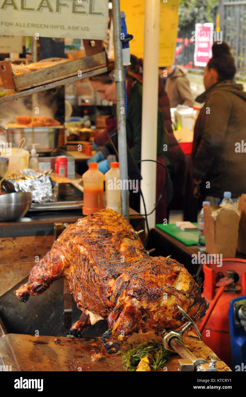 a whole pig or hog roasting on a spit at London's borough market. Hog ...