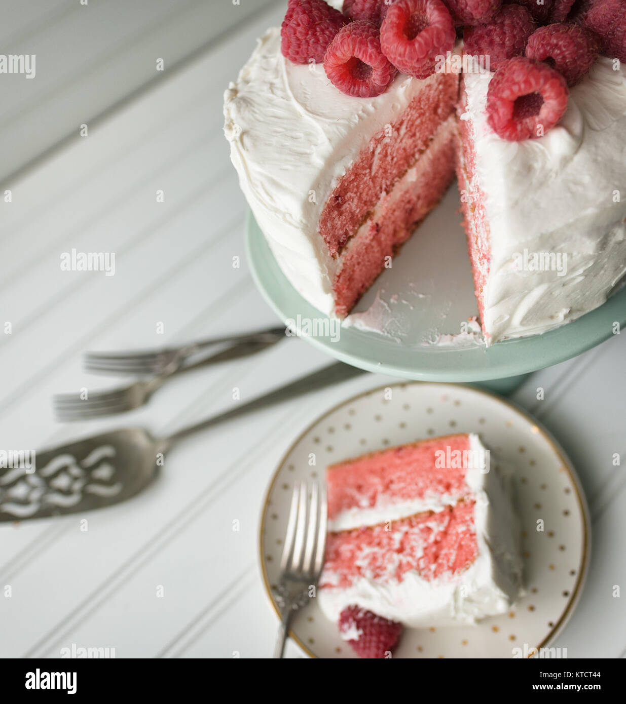 Whole raspberry cake with fresh raspberries on top being served from a ...