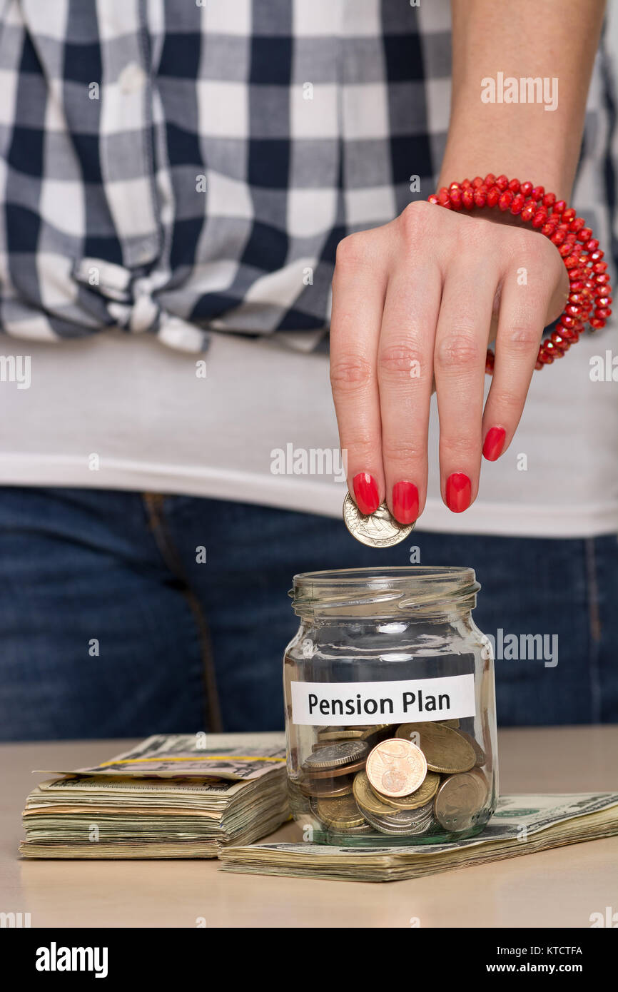 Young woman pouring coins into a jar. She is saving money for ...