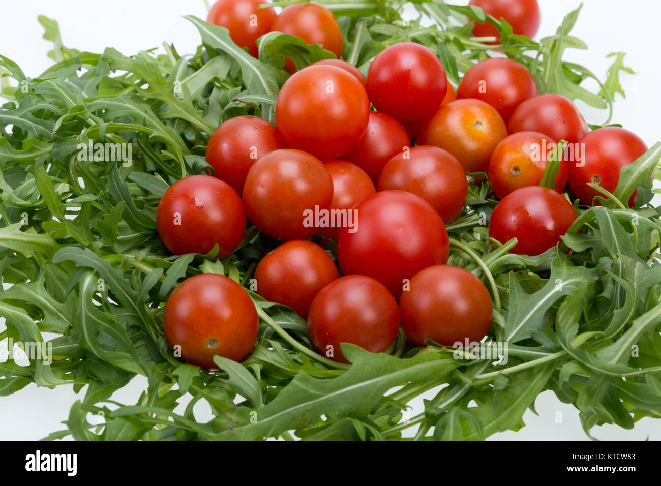 Heap of ruccola leaves and cherry tomatoes Stock Photo - Alamy