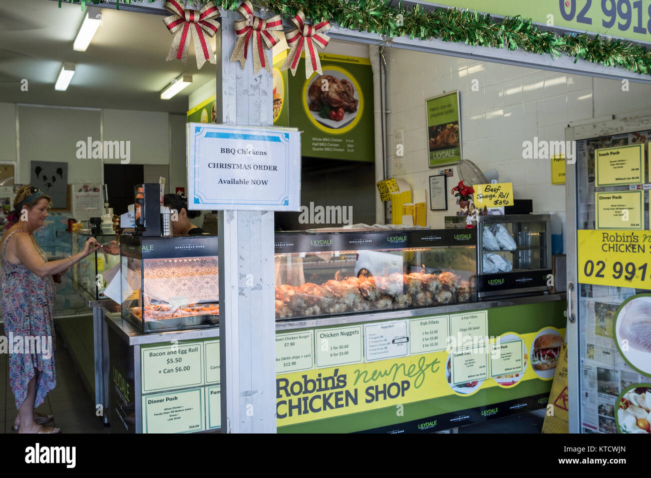 Lady in a Sydney chicken shop ordering a cooked chicken from the staff ...