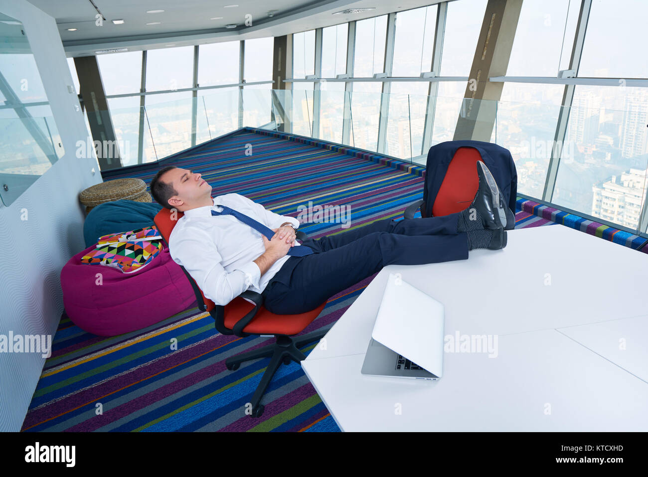 Young business man sleeping on the office desk Stock Photo - Alamy